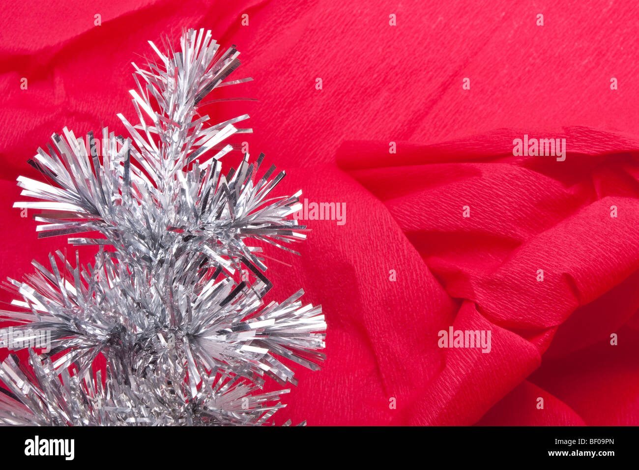 Silver tinsel abstract against red crepe paper christmas background ...