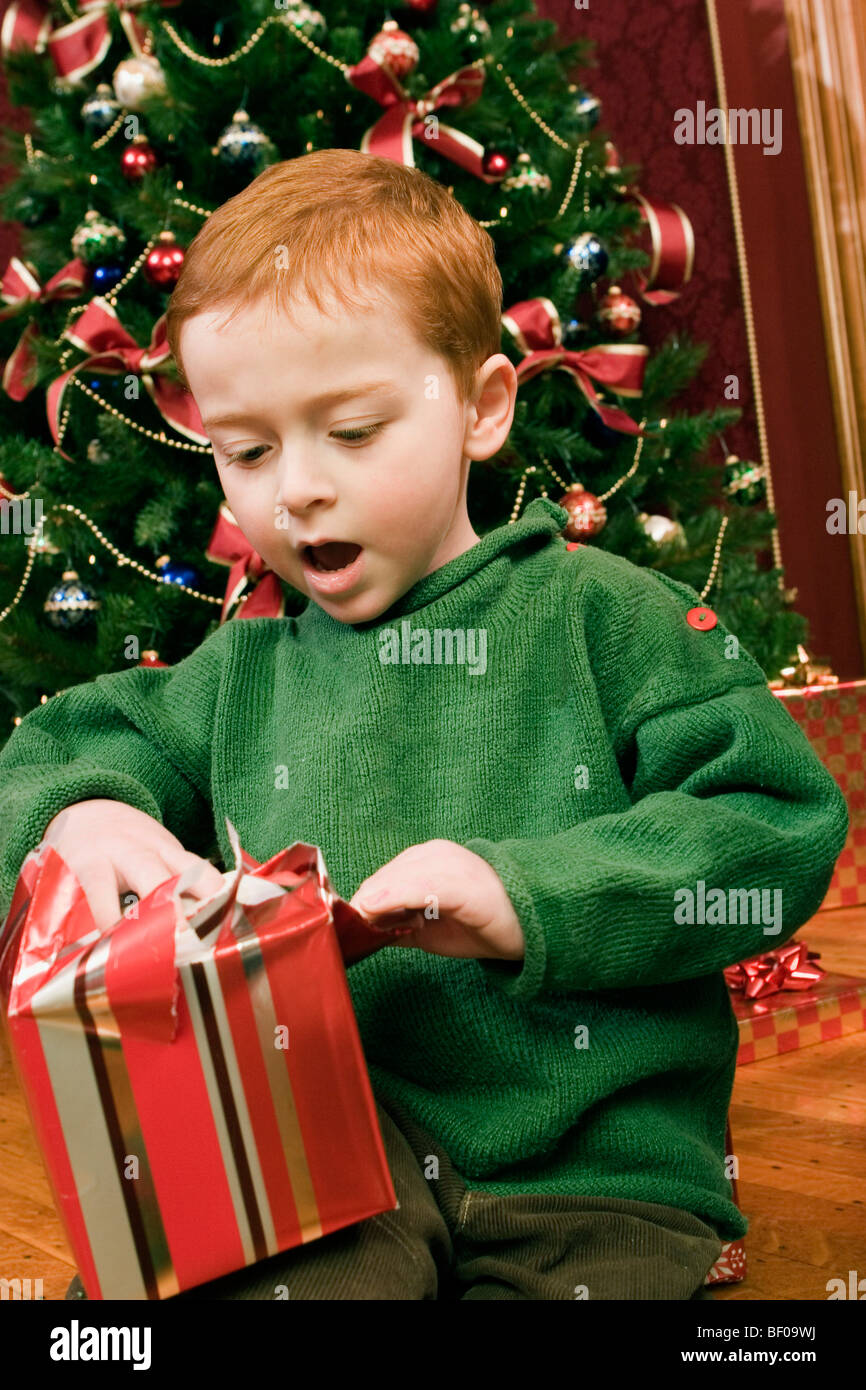 Boy opening a Christmas present Stock Photo - Alamy