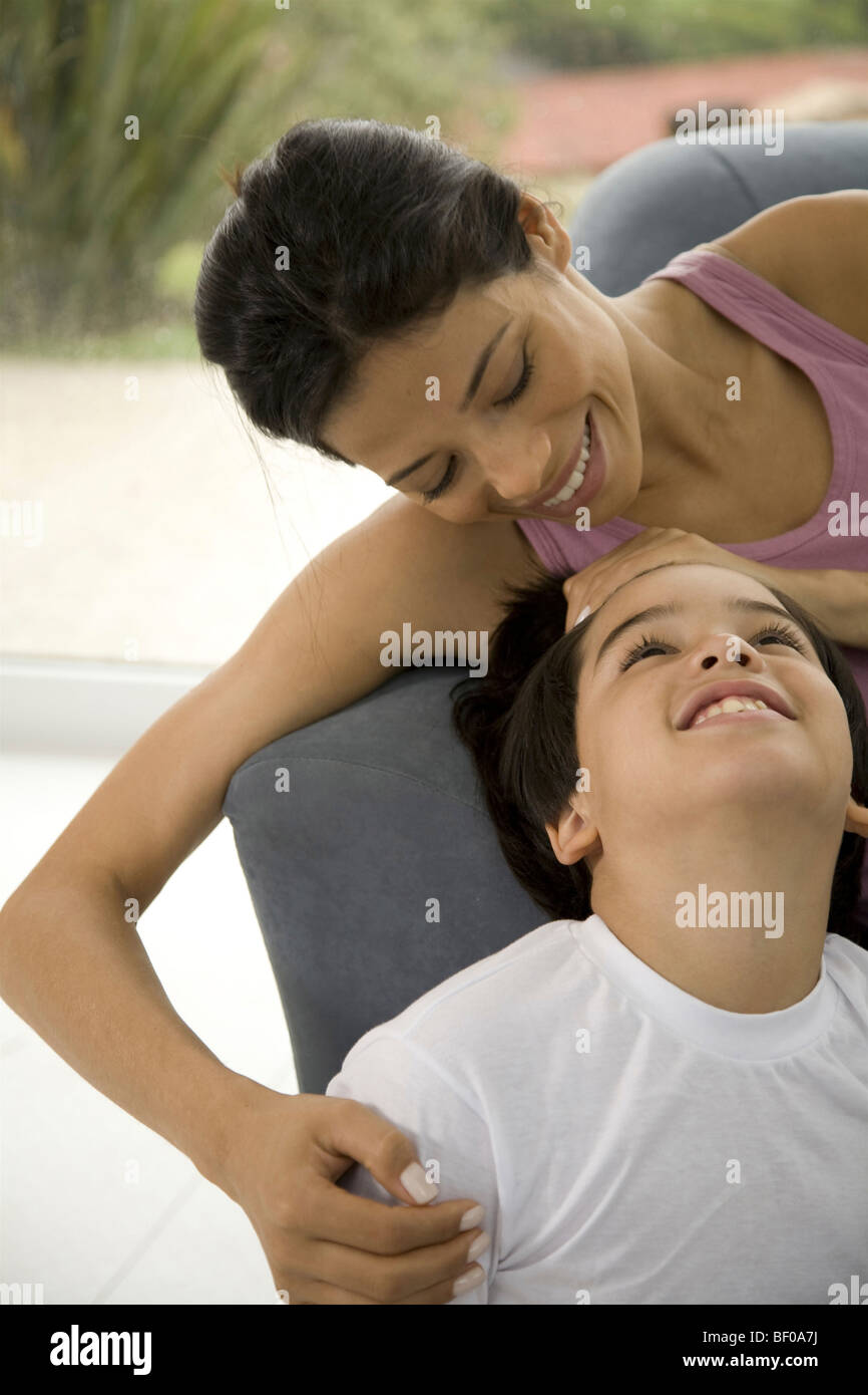 Young woman lying on a couch and touching her son's forehead Stock ...
