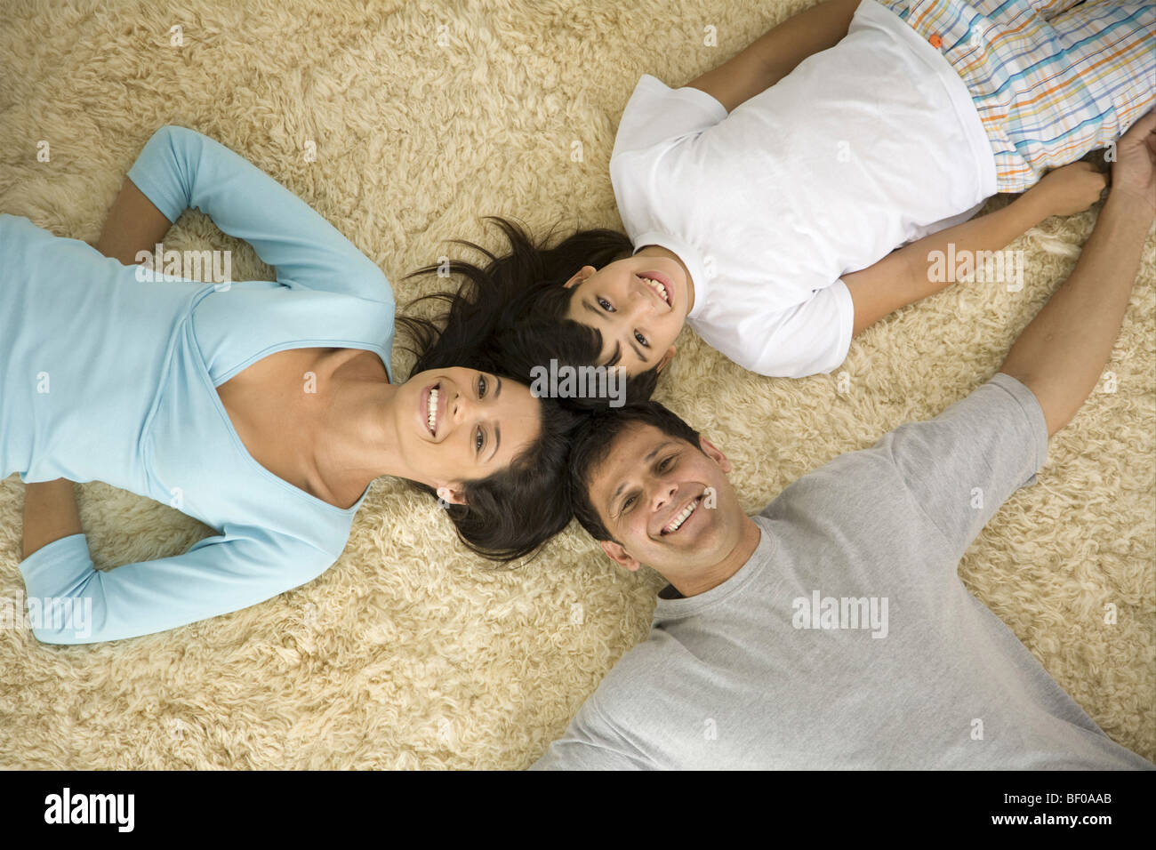 High angle view of a mature man and a young woman lying on a rug with ...