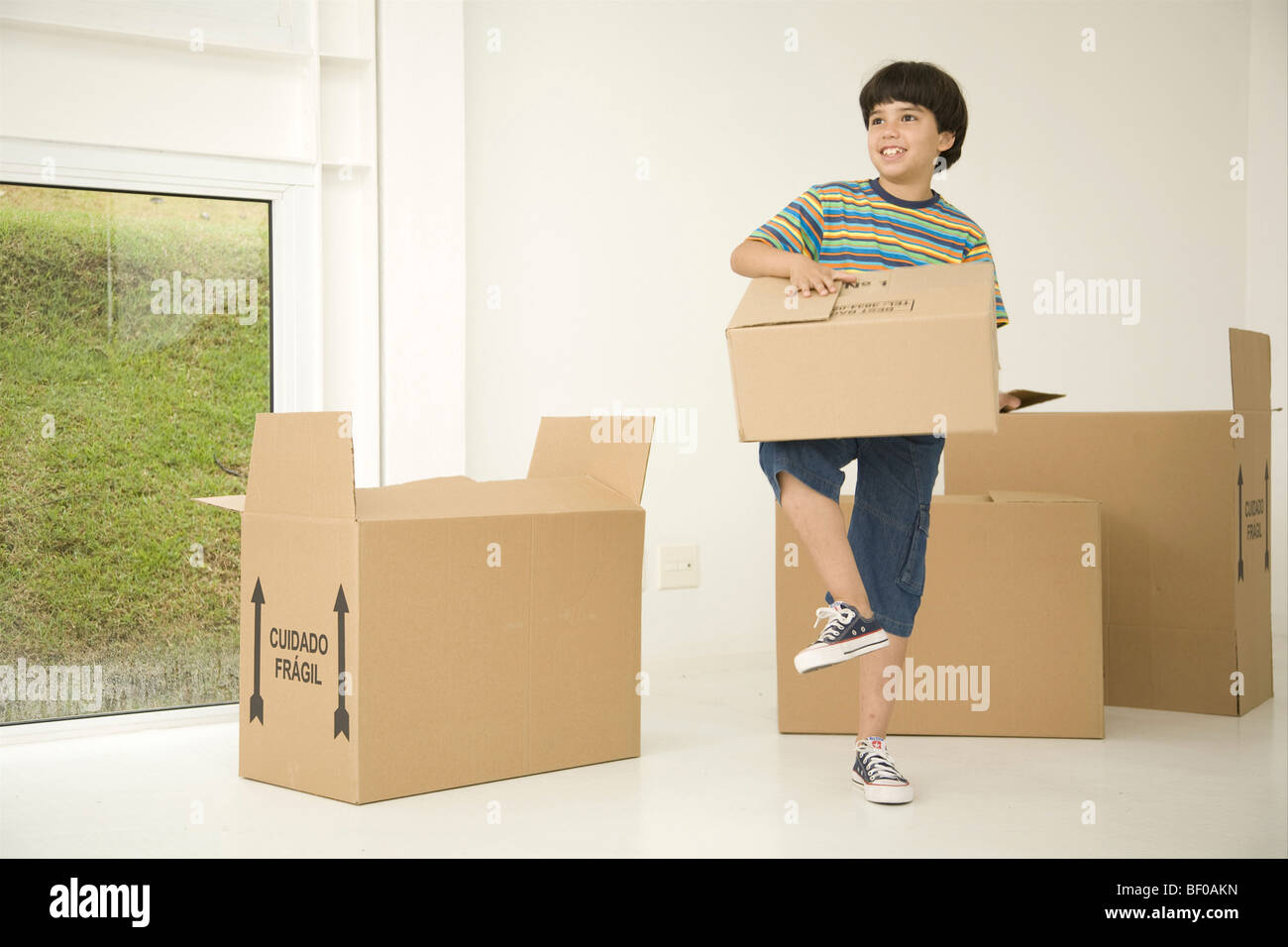 Boy holding a cardboard box and smiling Stock Photo - Alamy