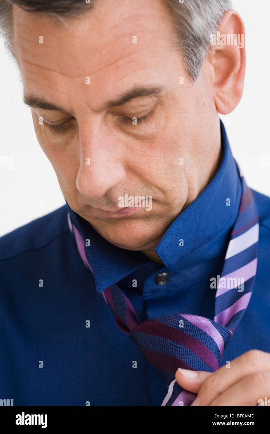 Close-up of a businessman tying his tie Stock Photo - Alamy