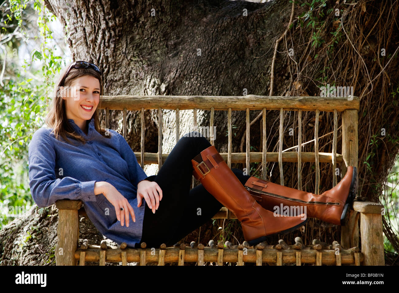 Portrait of a woman reclining on a bench Stock Photo - Alamy
