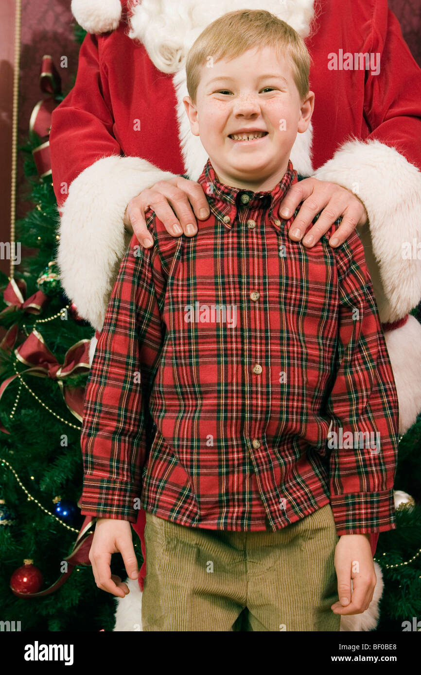 Boy standing in front of Santa Claus Stock Photo - Alamy