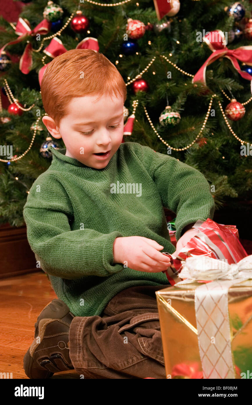 Boy opening a Christmas present Stock Photo - Alamy