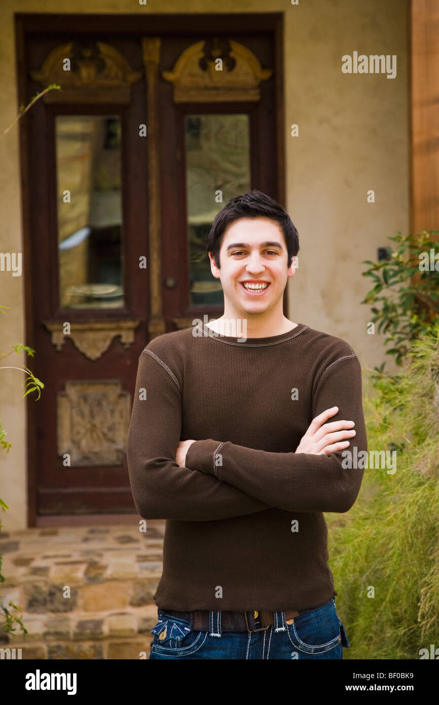 Man standing in front of a door and smiling Stock Photo - Alamy