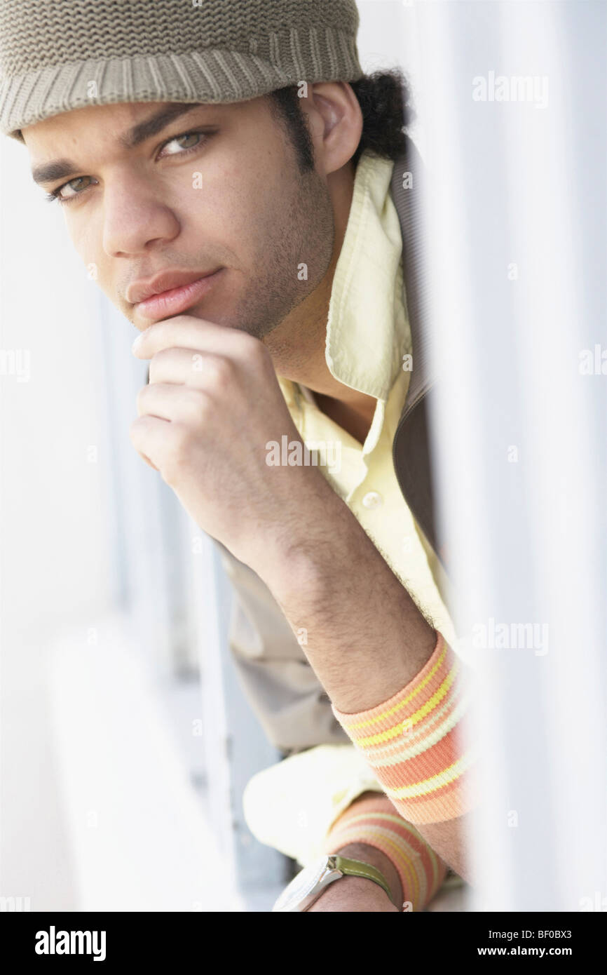 Portrait of a young man leaning over a window Stock Photo - Alamy