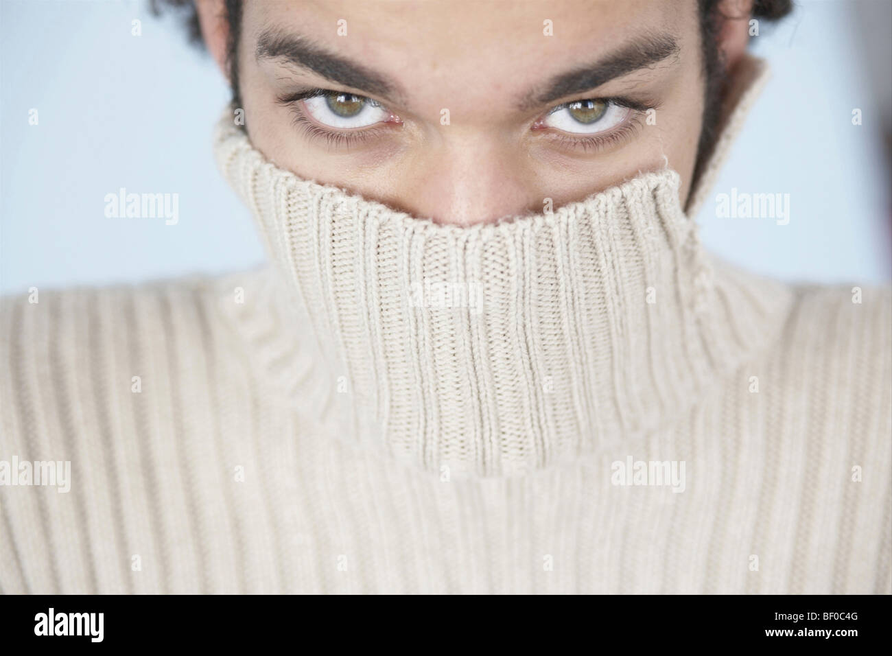 Portrait of a young man hiding his face with his sweater Stock Photo ...