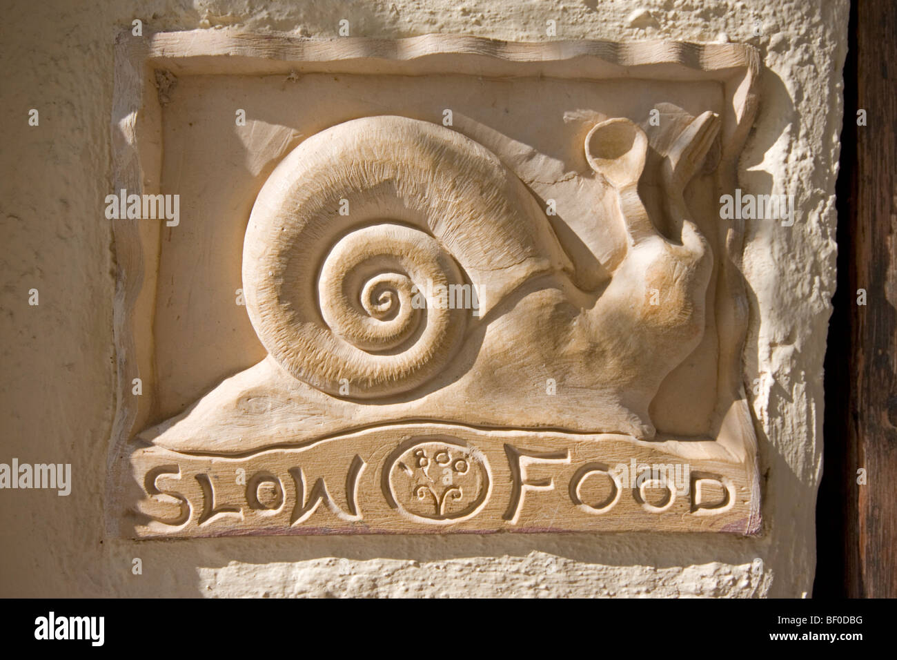 Wooden carved slow food sign outside restaurant Stock Photo - Alamy