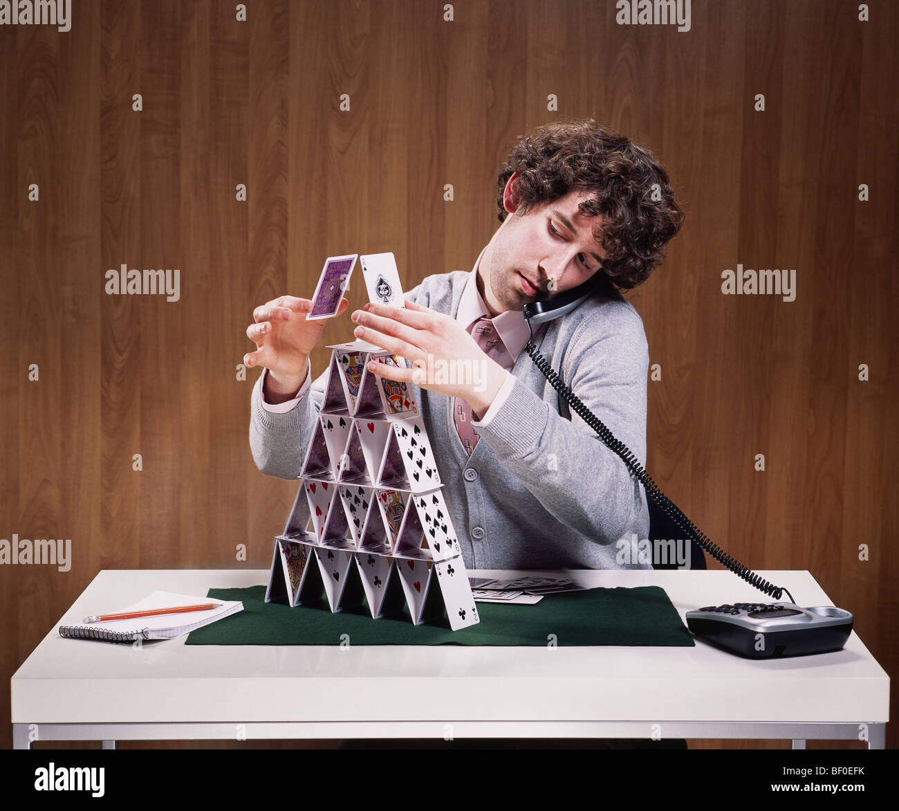 Businessman stacking cards on desk Stock Photo - Alamy
