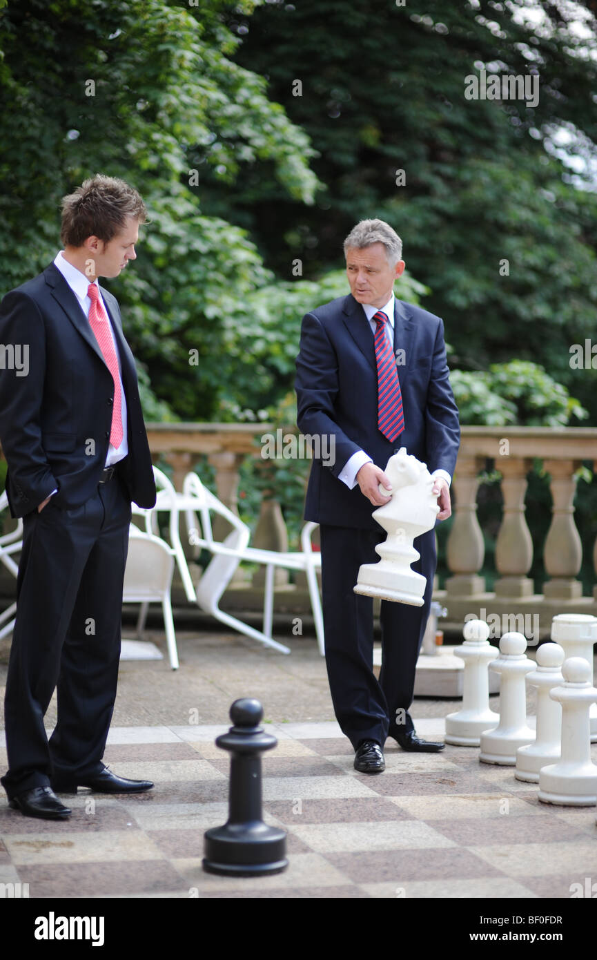 Two Businessmen Playing Giant Chess Stock Photo - Alamy