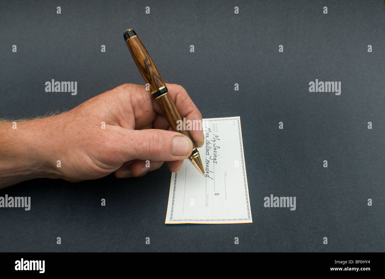 male hand writing check to savings for more dollars needed Stock Photo ...