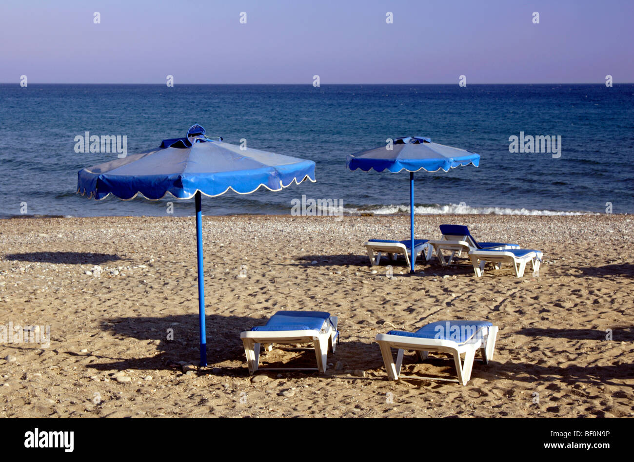 Deck chairs and parasols on sandy beach Lothiarika , near Lardos ...