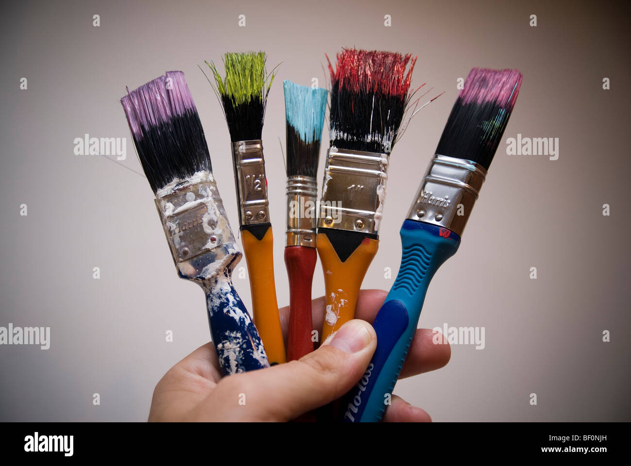 A handful of colourful paint brushes with brightly coloured paint Stock ...