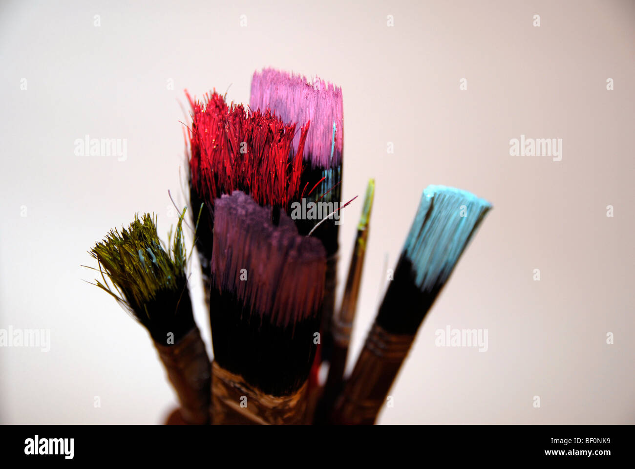 A handful of colourful paint brushes with brightly coloured paint Stock ...