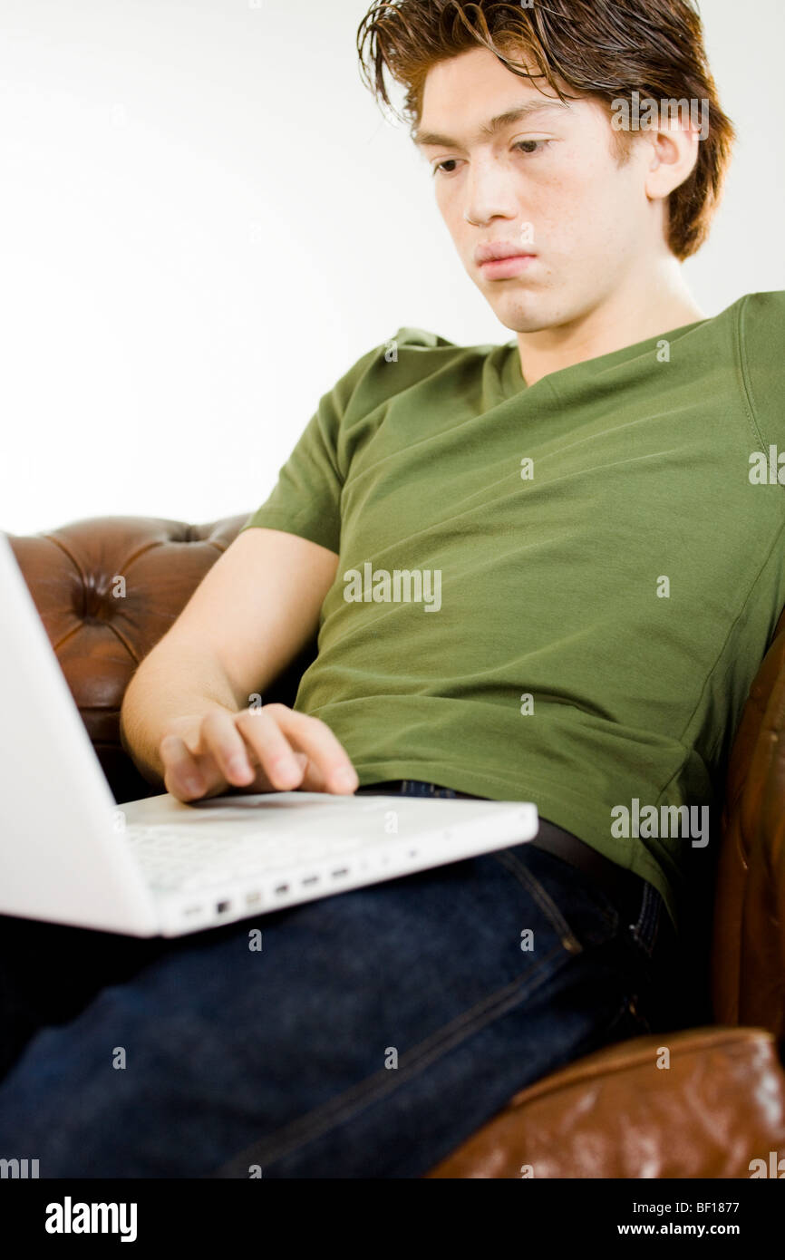 A teenage boy using a laptop Stock Photo - Alamy