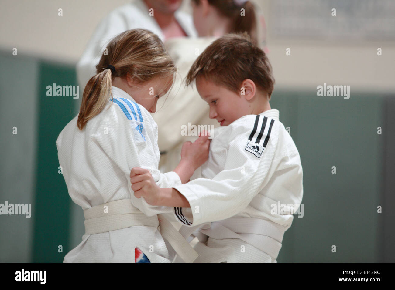 A judo class for kids and children with adults supervising the training ...