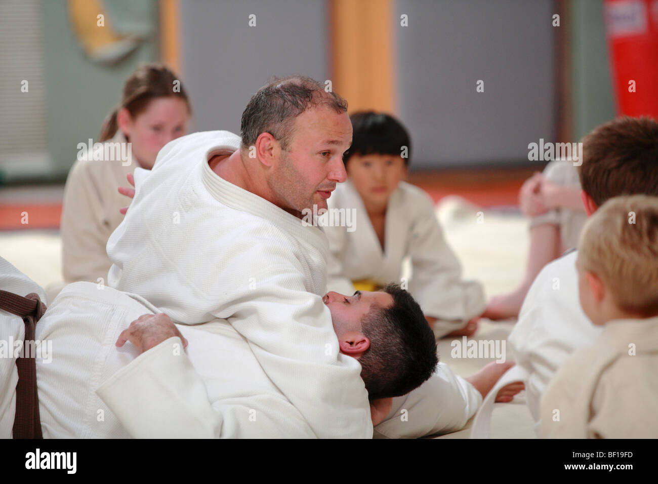A judo class for kids and children with adults supervising the training ...