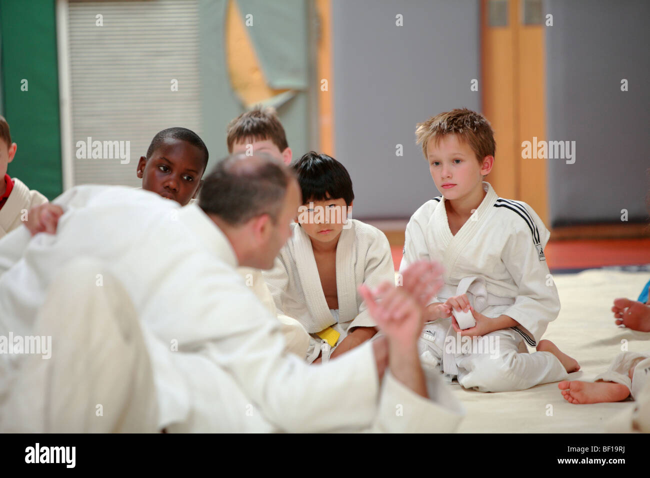A judo class for kids and children with adults supervising the training ...