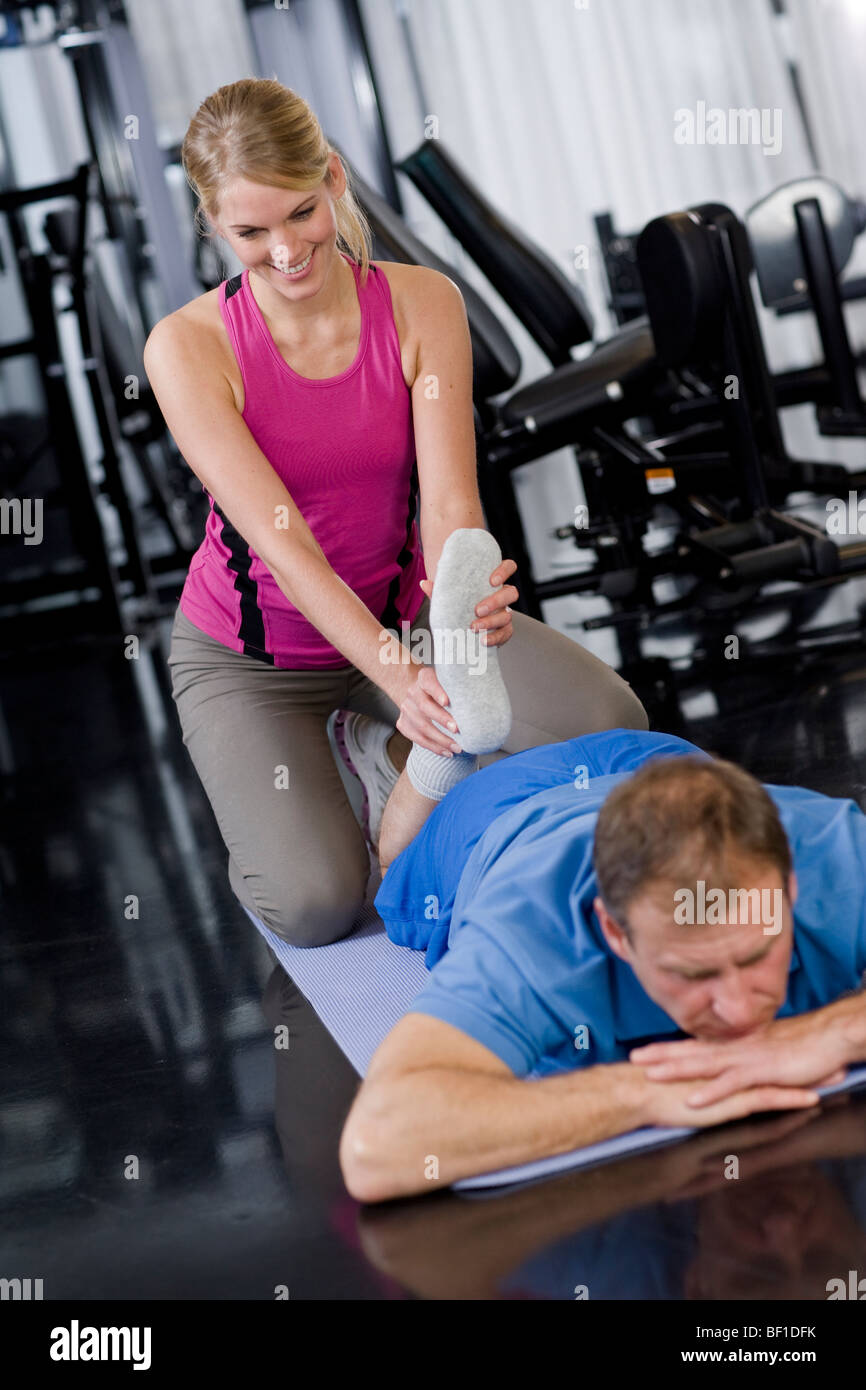 A woman and a man doing stretching exercises at a gym, Sweden Stock ...