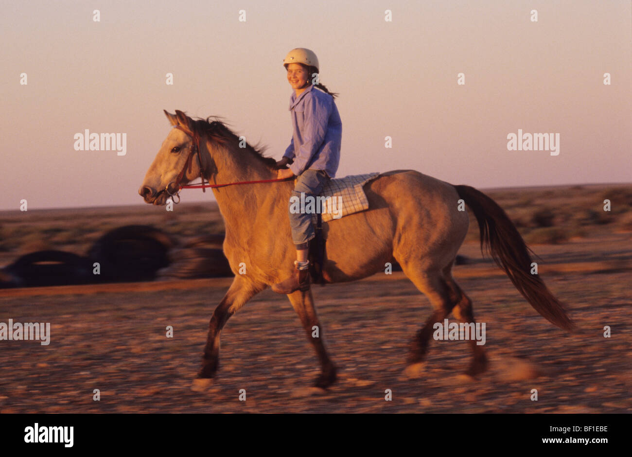 Young teenage girl riding horse, outback desert, Queensland Australia ...