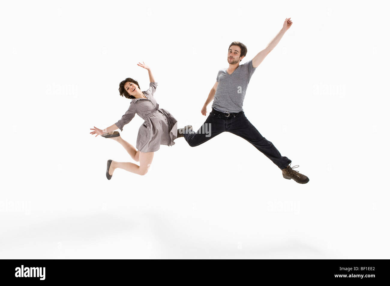 A young man and a young woman jumping mid-air Stock Photo - Alamy