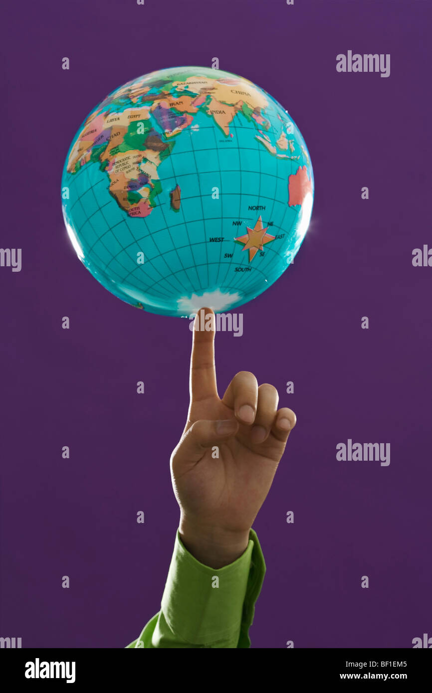 A globe balanced on a human finger Stock Photo - Alamy