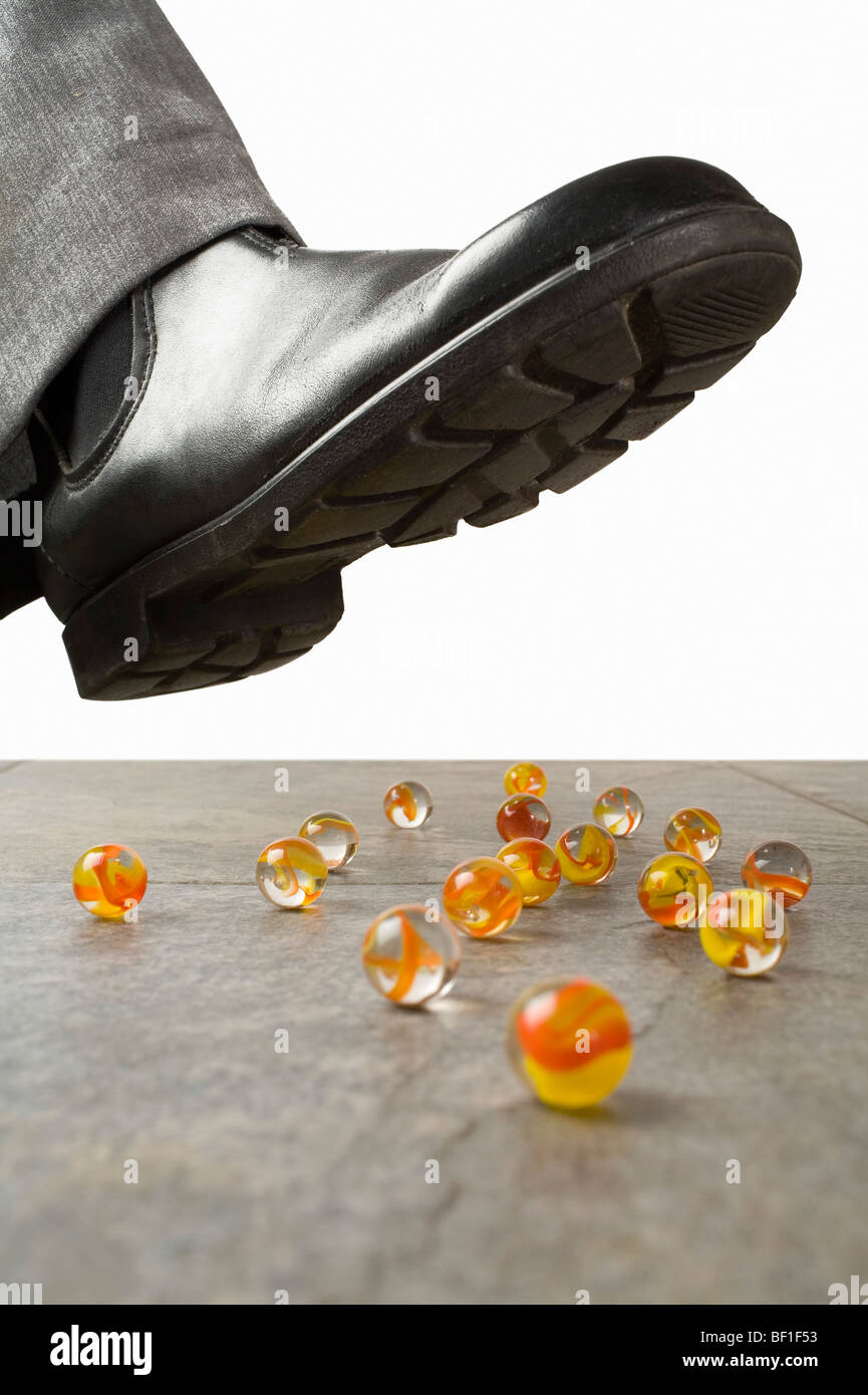 A foot above scattered marbles Stock Photo - Alamy