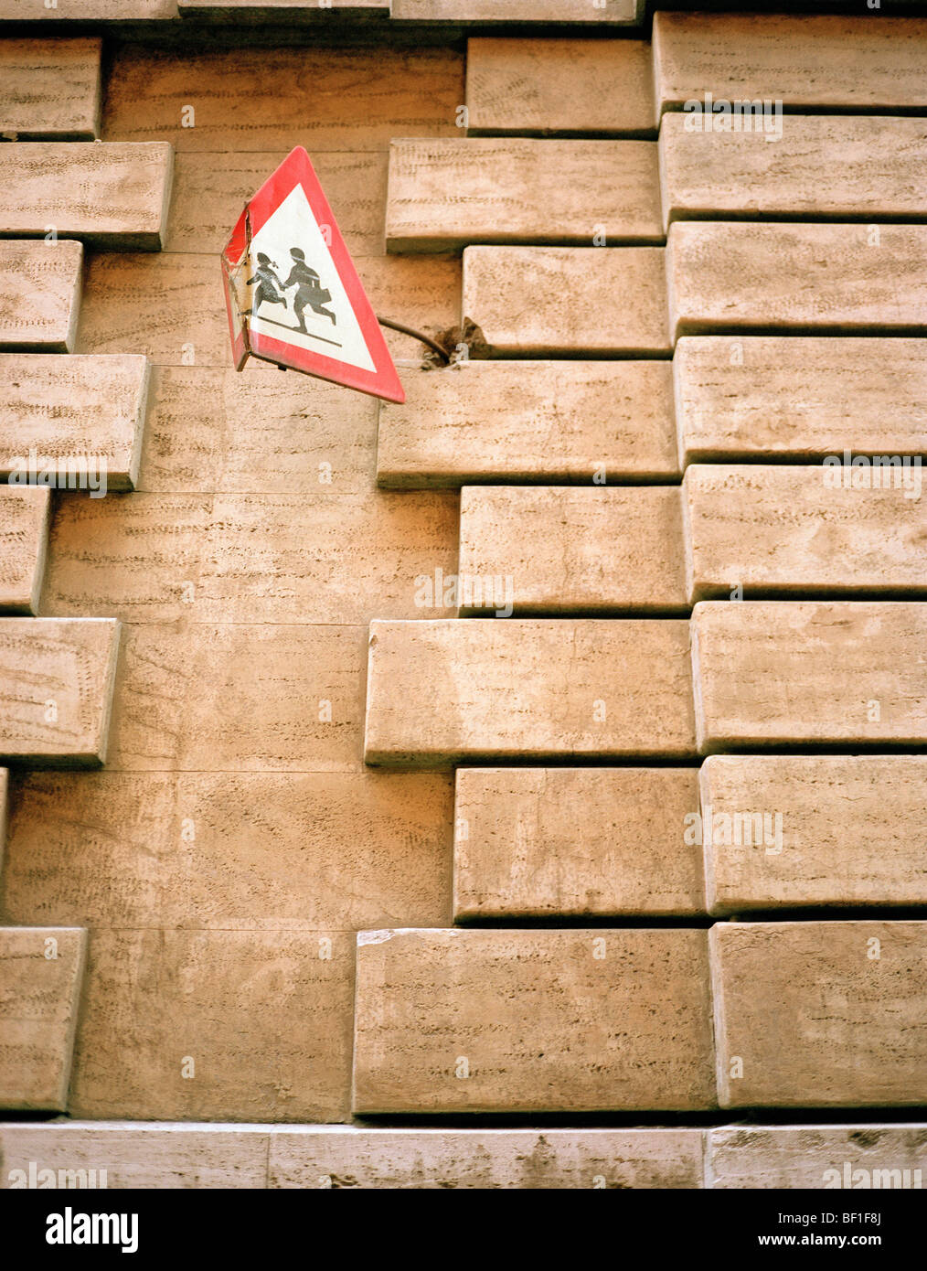 Wall with a bent sign for a school crossing Stock Photo - Alamy