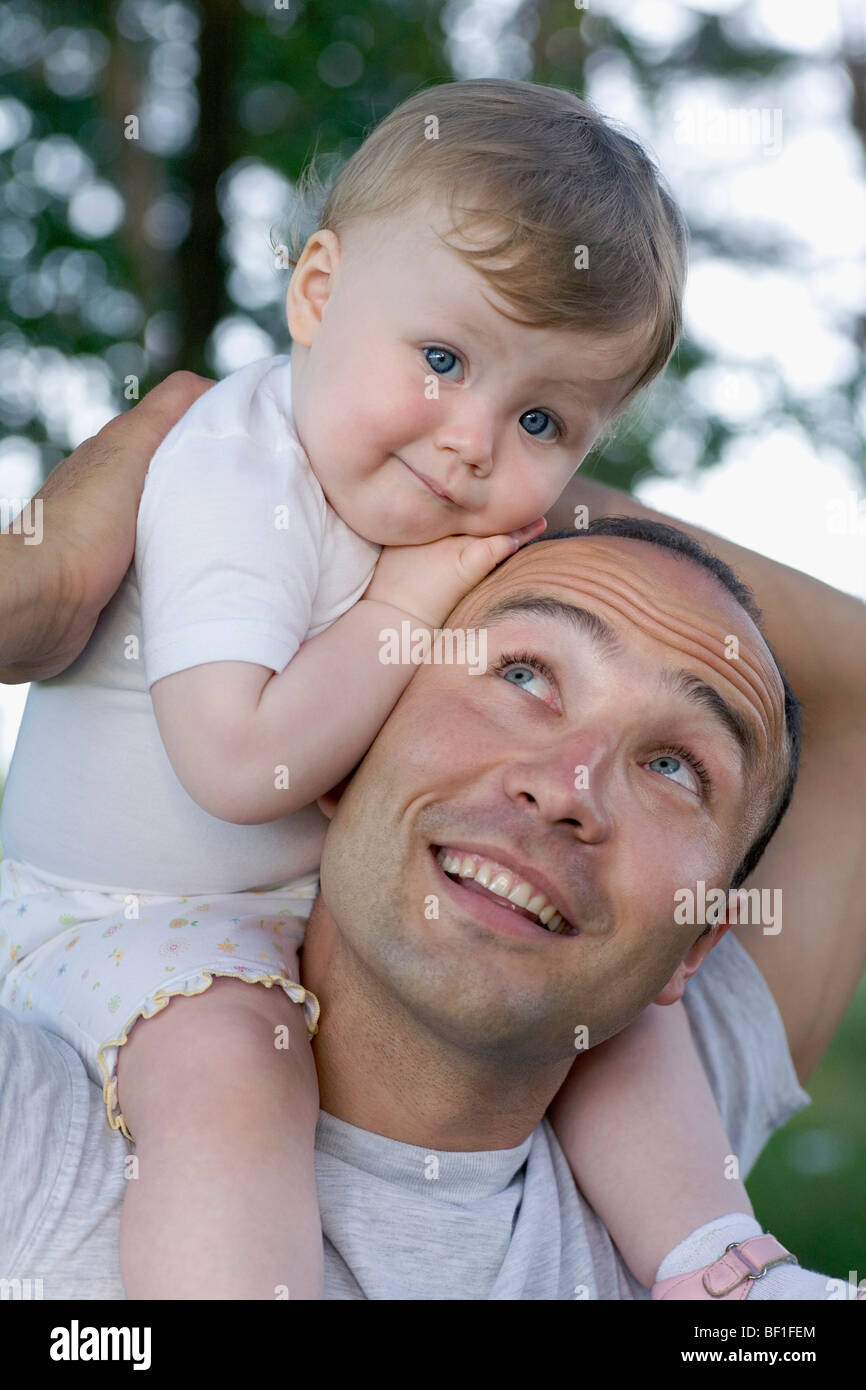 A child sitting on the shoulders of her father Stock Photo - Alamy