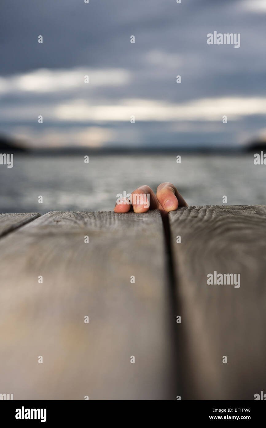 The fingers grasping the edge of a jetty, Sweden Stock Photo - Alamy