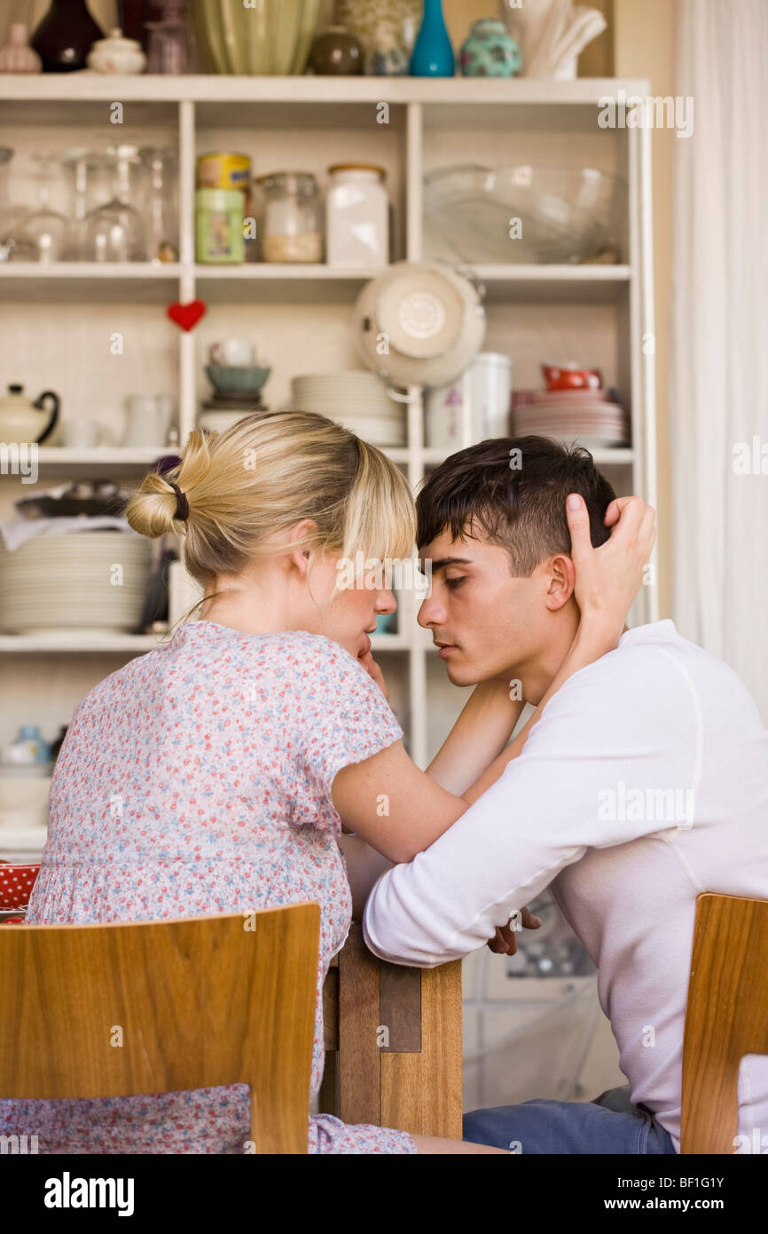 A young passionate couple sitting in a domestic kitchen Stock Photo - Alamy