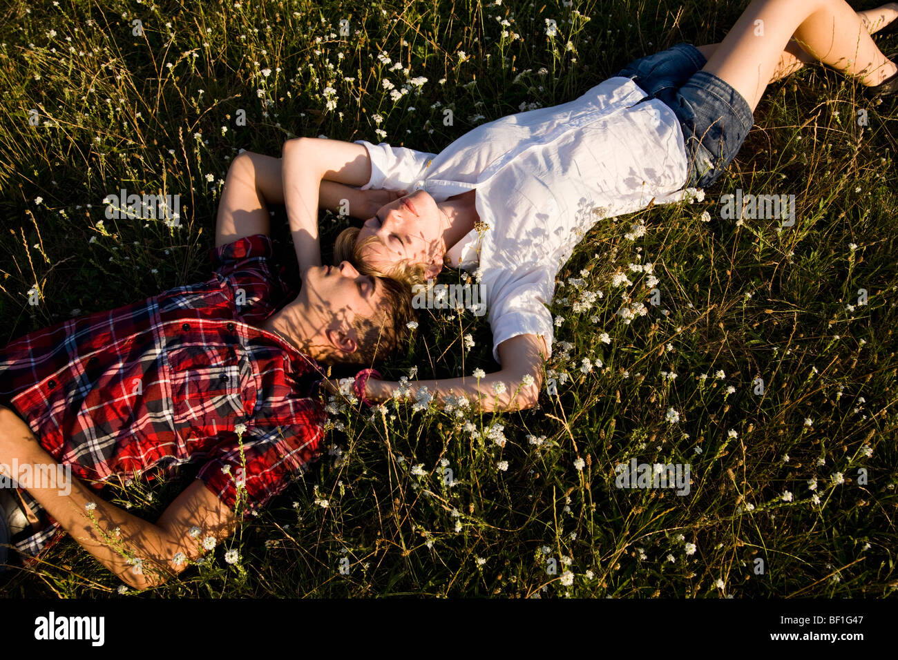 A young couple napping in a field Stock Photo - Alamy