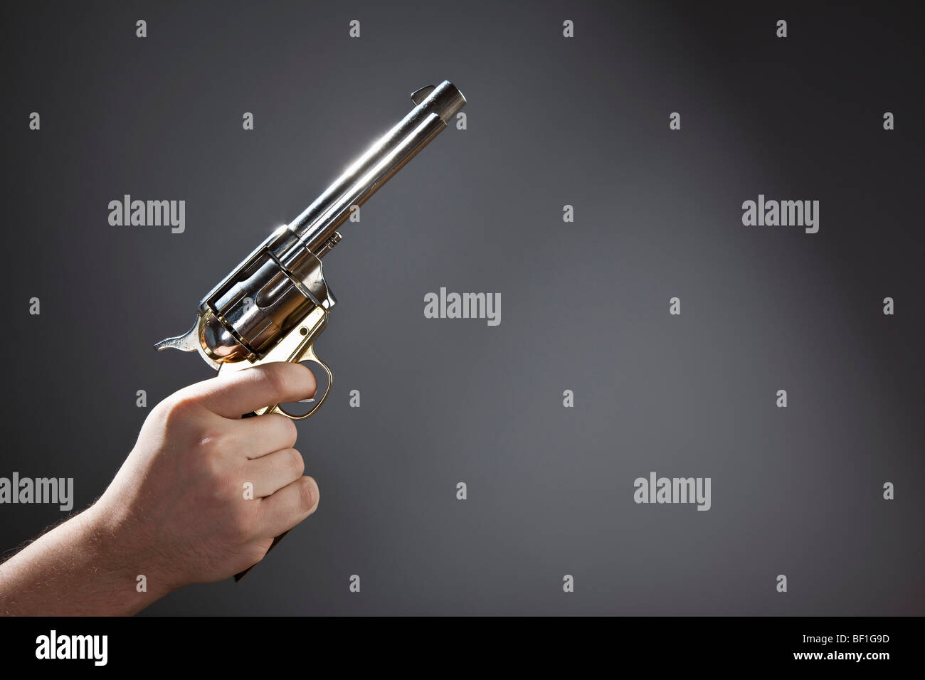 A hand holding a pistol Stock Photo - Alamy