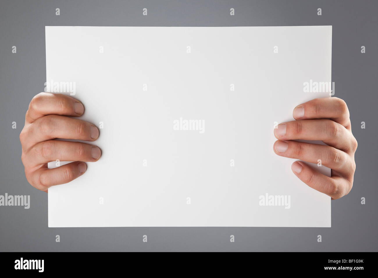 Hands holding up a white piece of paper Stock Photo - Alamy