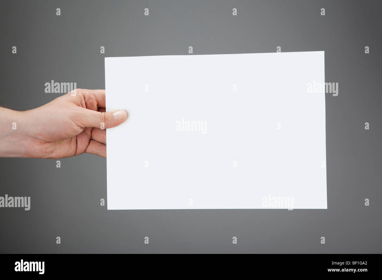 A hand holding up a white piece of paper Stock Photo - Alamy