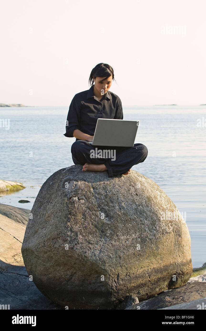 Woman seated on rocks hi-res stock photography and images - Alamy