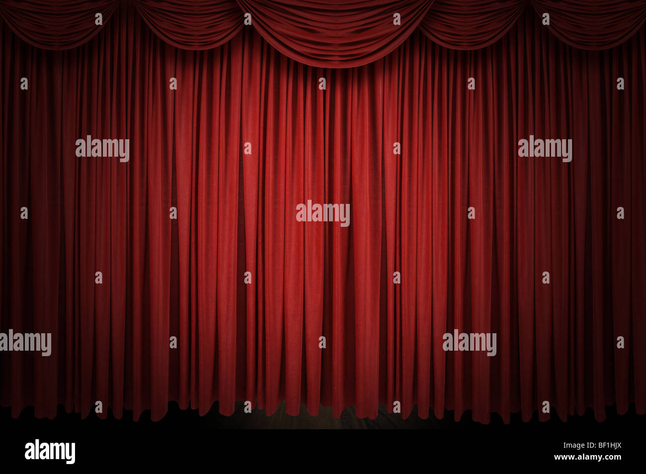 Large red curtain stage opening with spot lights and dark background ...