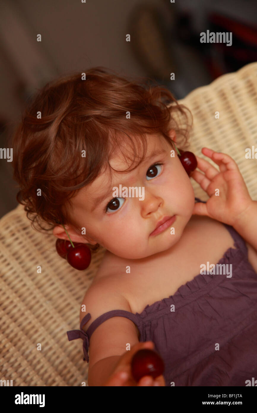 Eighteen months old baby girl eating cherries Stock Photo - Alamy