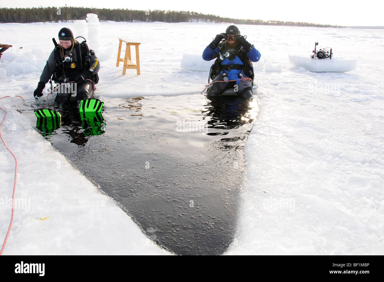 ice diving, ice diver sitting on the ice hole, White Sea, Russia Stock ...