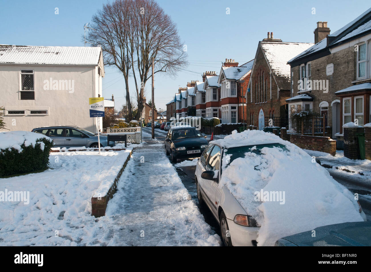 A suburban street covered in snow with blue sky Stock Photo - Alamy