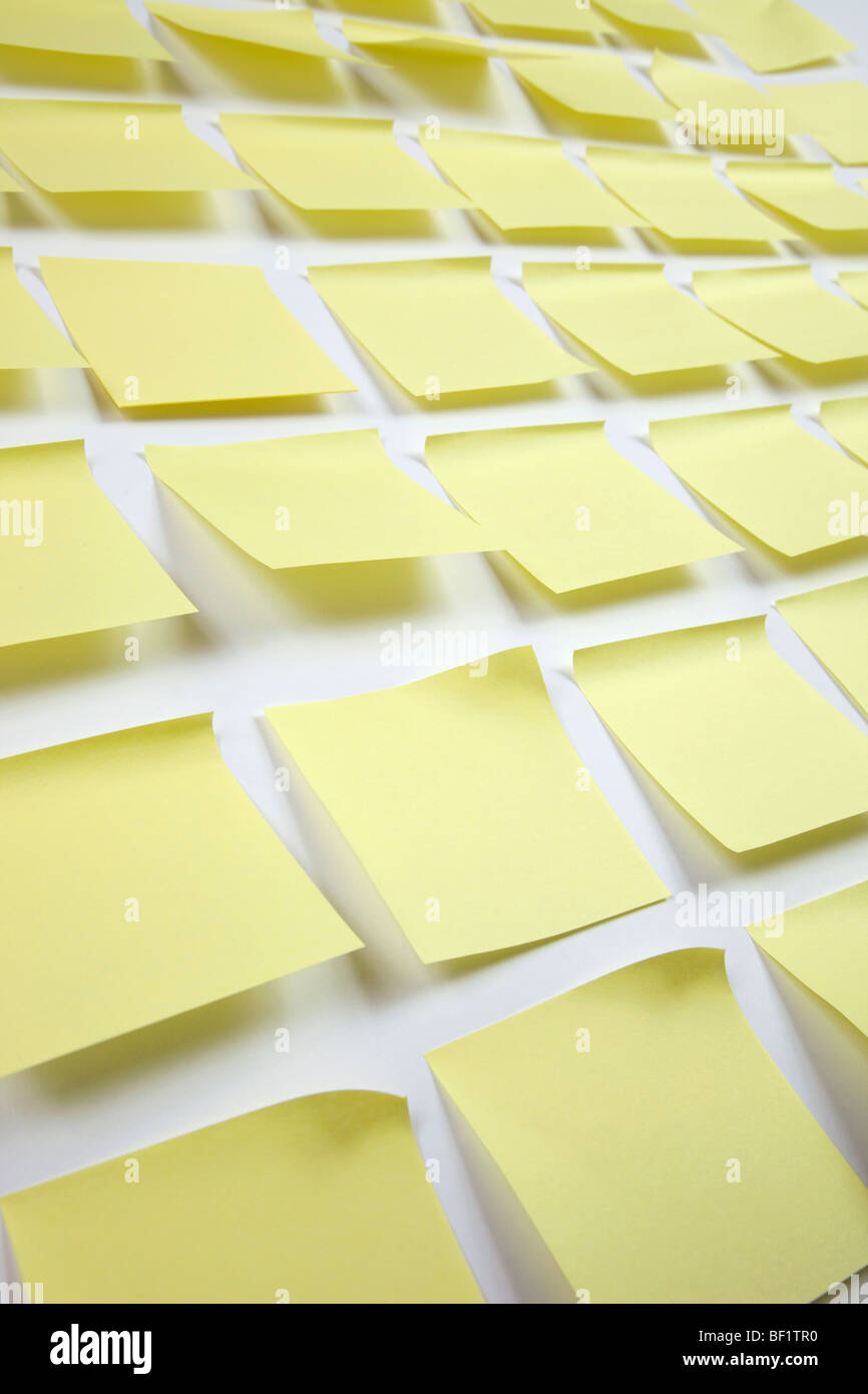 Yellow note pages on a white background Stock Photo - Alamy