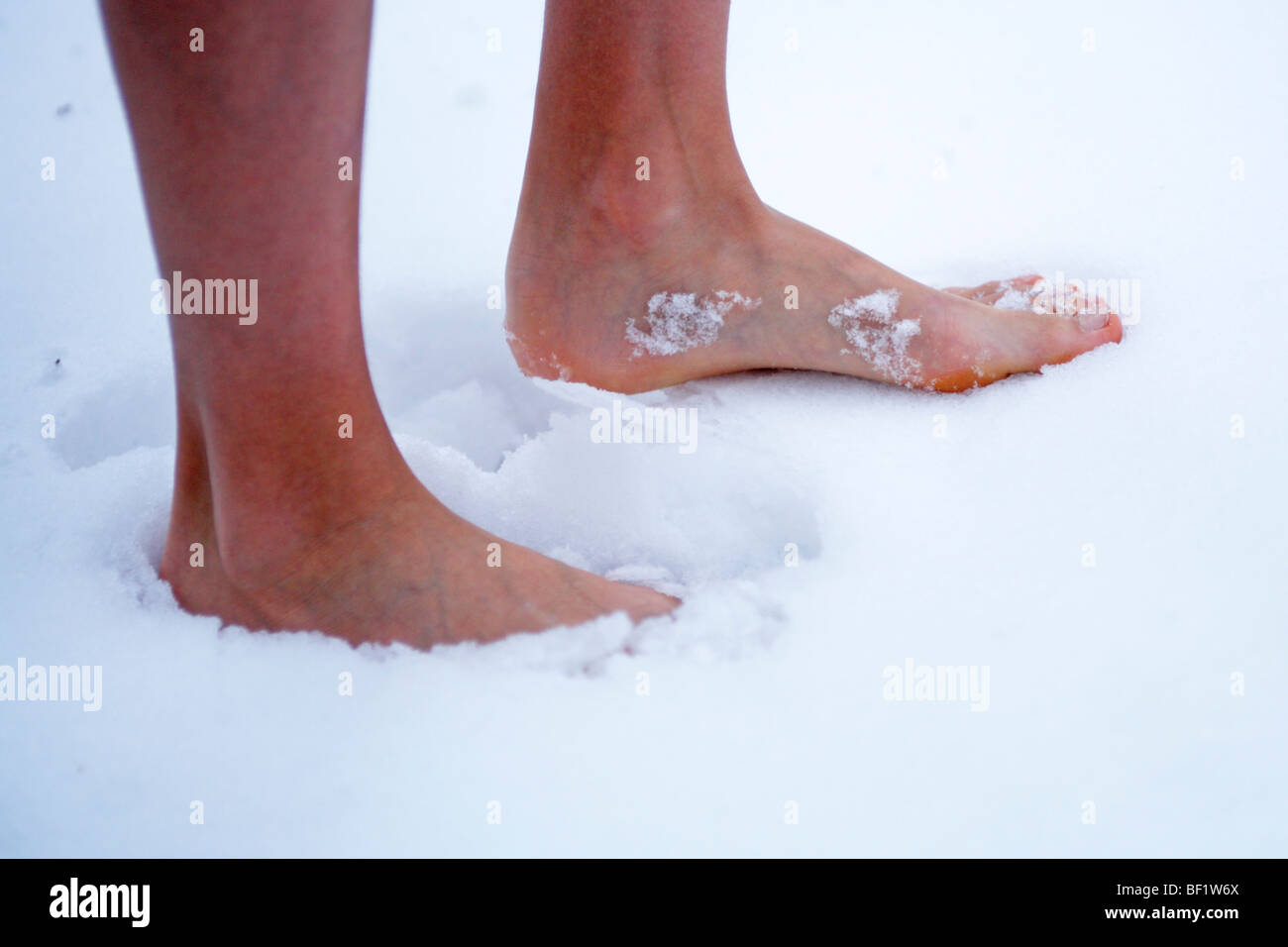 legs of a young boy walking barefoot in snow Stock Photo - Alamy