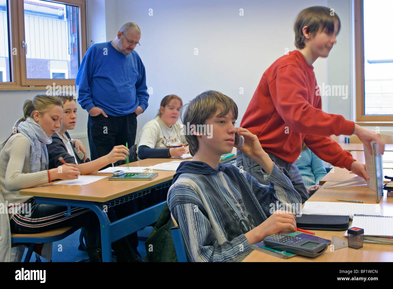 kids at school, one using his mobile phone during class Stock Photo - Alamy