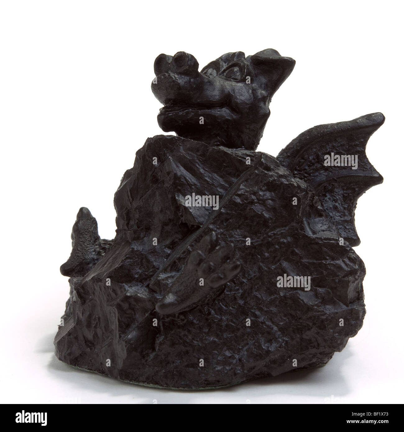 Cheeky welsh dragon carved from coal isolated against white background ...