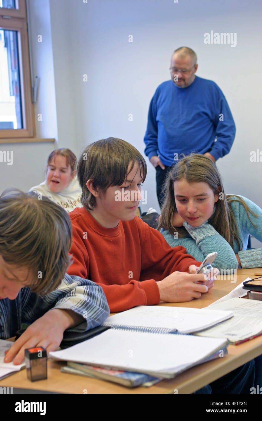 kids at school, one using his mobile phone during class Stock Photo - Alamy