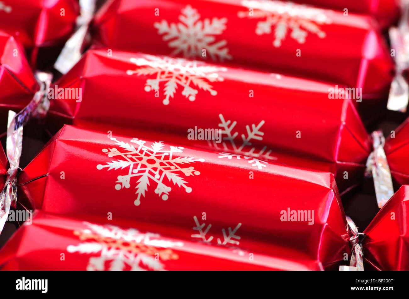 Closeup of many red Christmas crackers in a row Stock Photo - Alamy