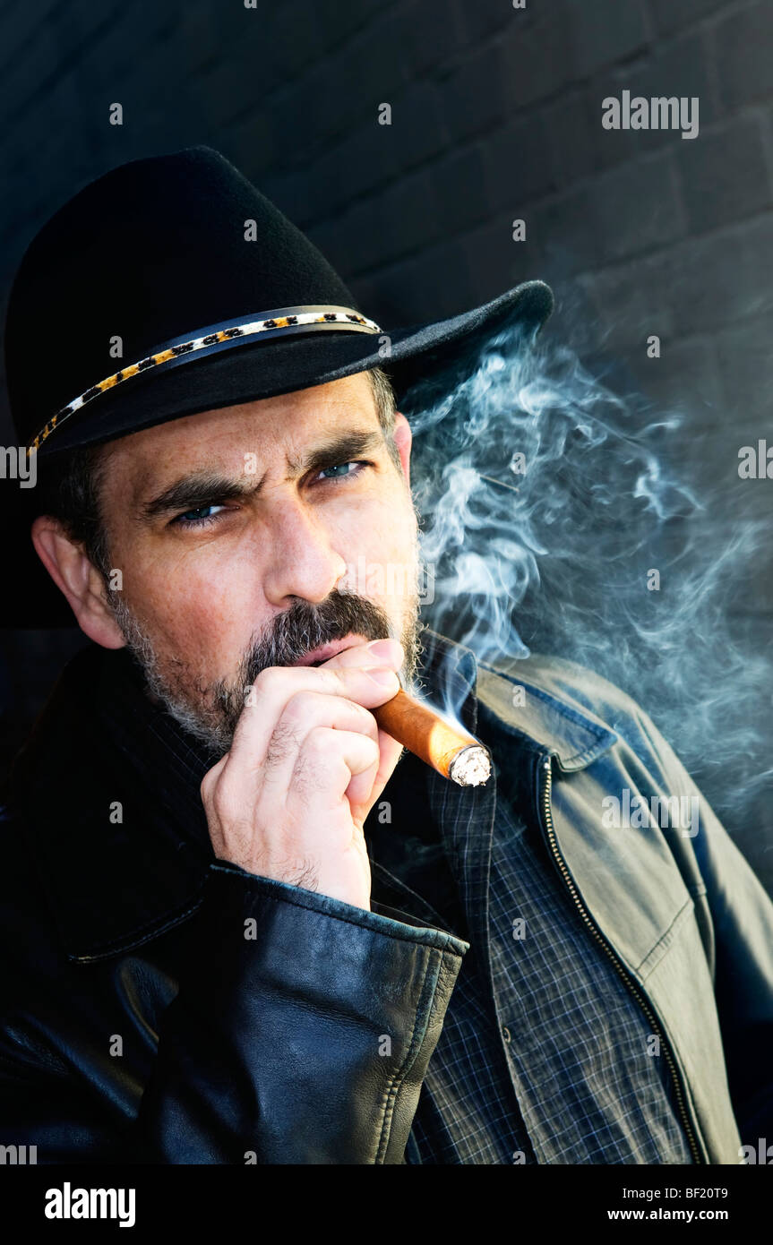 Man with beard in cowboy hat smoking cigar Stock Photo - Alamy