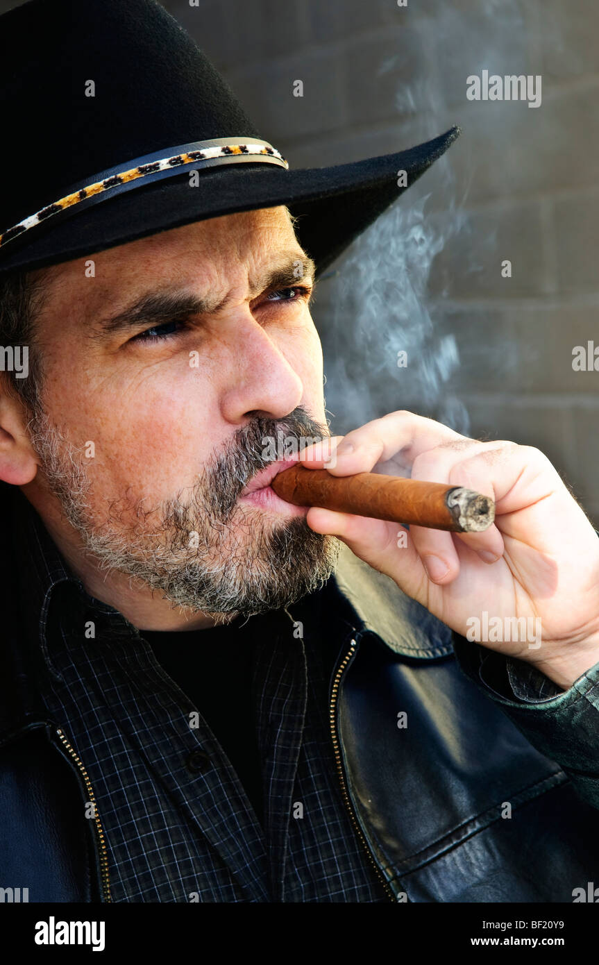 Man with beard in cowboy hat smoking cigar Stock Photo - Alamy