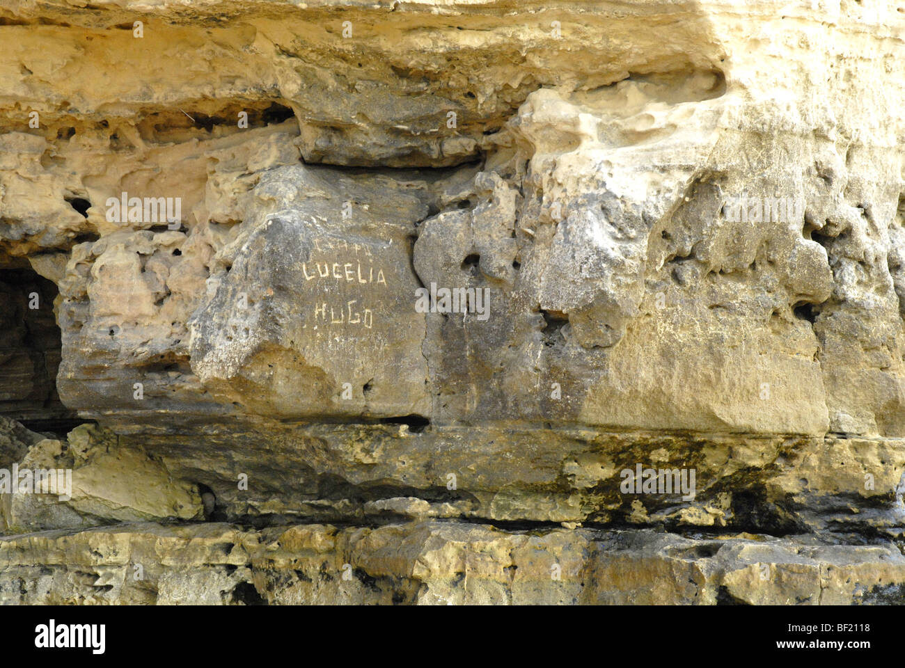 Writing carved in the stone on a beautiful rocky beach on Falesia beach ...